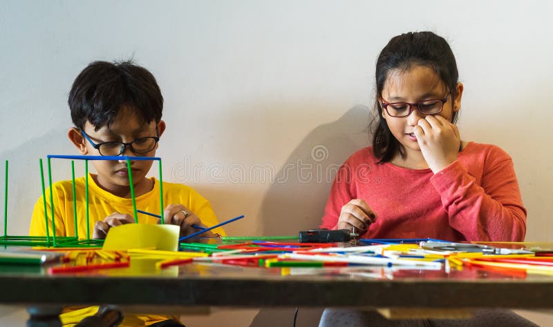 Young Children are Constructing Colorful Plastic Sticks with Glue Gun ...
