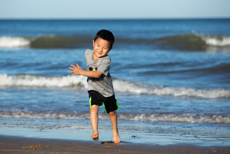 A Young Chinese Boy Playing and Running on the Beach Stock Image ...