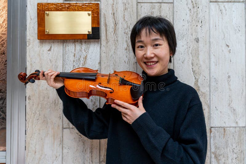 Young Chinese Female Violin Maker Showing Her Freshly Made Violin ...