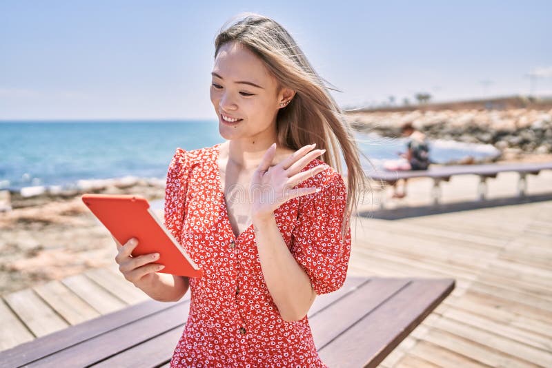 Young Chinese Girl Having Video Call Using Touchpad at the Beach Stock ...