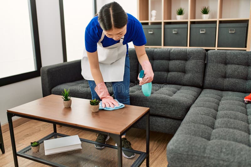 Young Chinese Housewife Cleaning Table Using Diffuser and Rag at Home ...