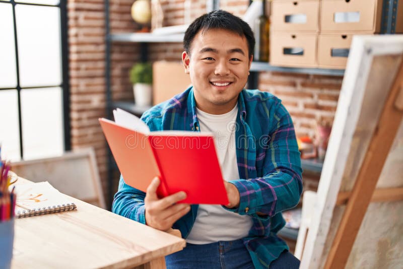 Young Chinese Man Artist Reading Book at Art Studio Stock Photo - Image ...