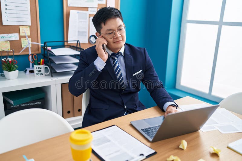 Young Chinese Man Business Worker Using Laptop Talking on Smartphone at ...