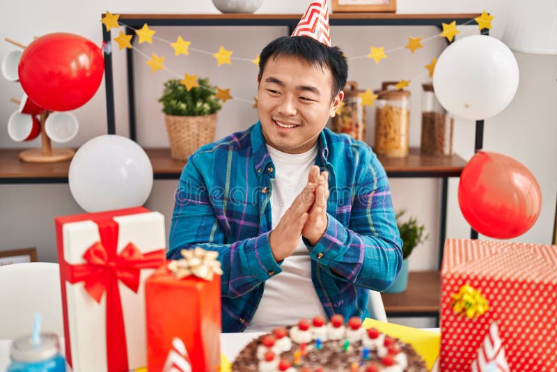 Young Chinese Man Celebrating Birthday Sitting on Table at Home Stock ...