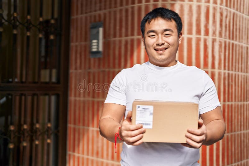Young Chinese Man Courier Holding Package at Street Stock Photo - Image ...