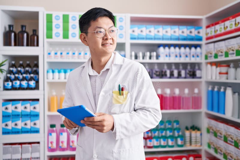Young Chinese Man Pharmacist Using Touchpad Working at Pharmacy Stock ...