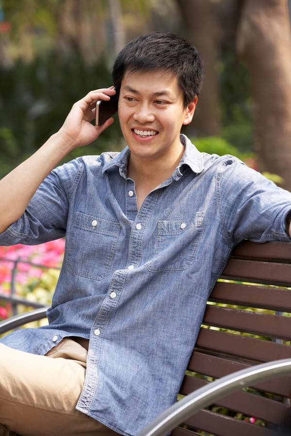 Young Chinese Man Relaxing on Park Bench Stock Photo - Image of ...