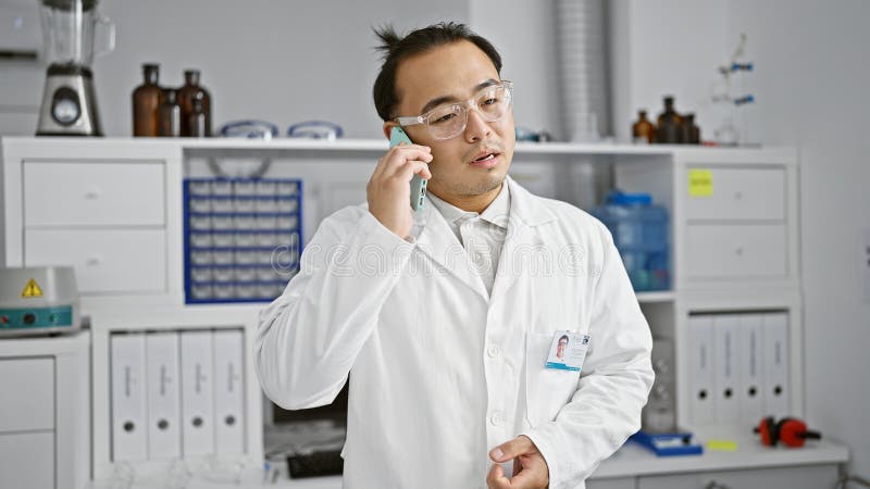 Young Chinese Man Scientist Talking on Smartphone at Laboratory Stock ...