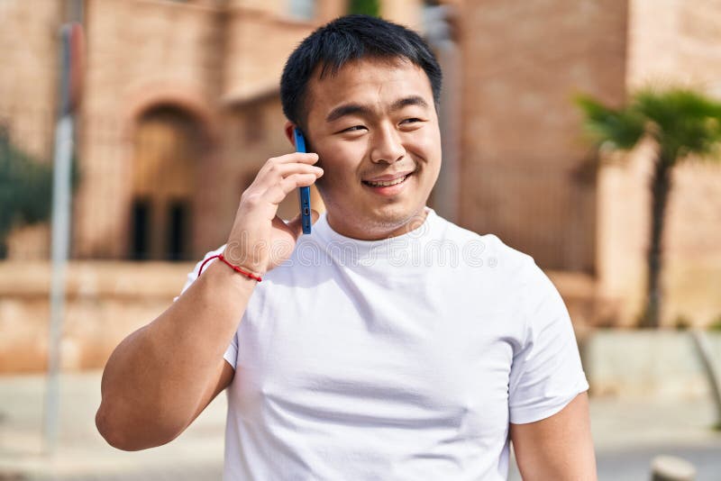 Young Chinese Man Smiling Confident Talking on the Smartphone at Street ...