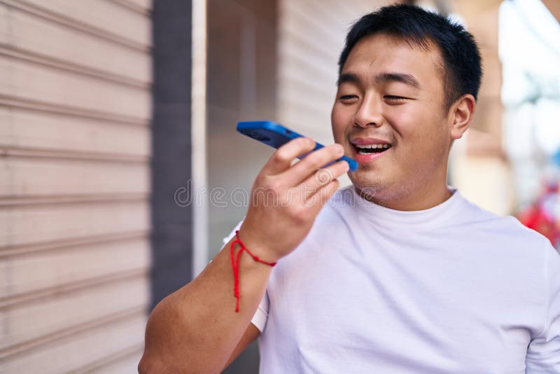Young Chinese Man Smiling Confident Talking on the Smartphone at Street ...