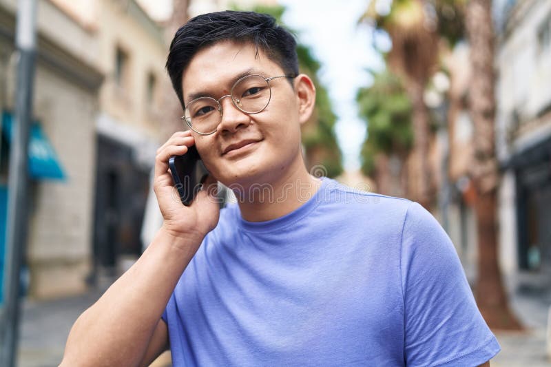 Young Chinese Man Smiling Confident Talking on the Smartphone at Street ...