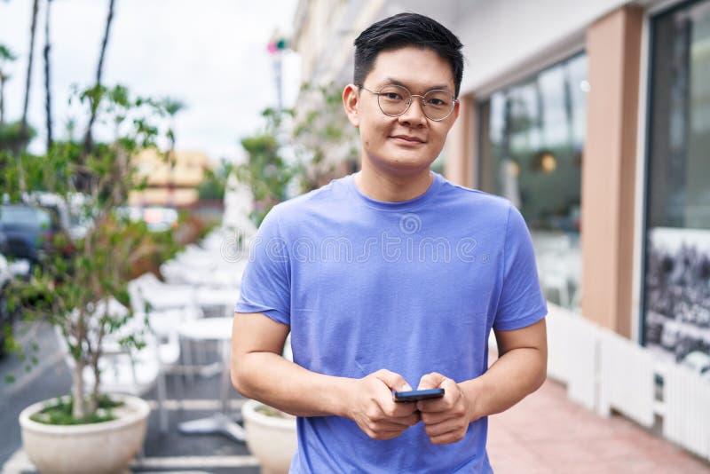 Young Chinese Man Smiling Confident Using Smartphone at Coffee Shop ...