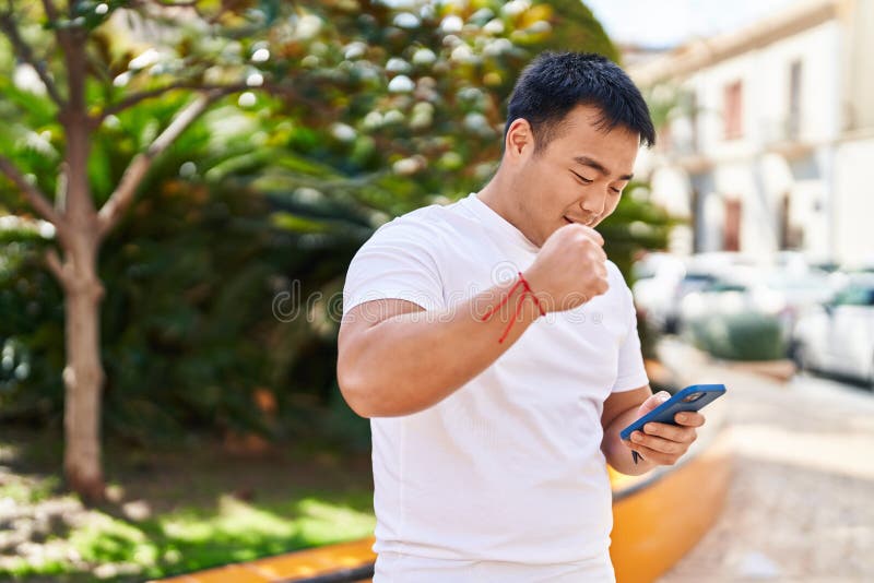 Young Chinese Man Smiling Confident Using Smartphone at Park Stock ...