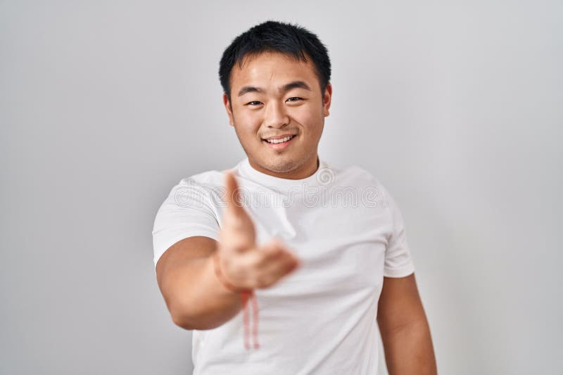 Young Chinese Man Standing Over White Background Smiling Cheerful ... Young Chinese Man Standing Over White Background Smiling Cheerful ...