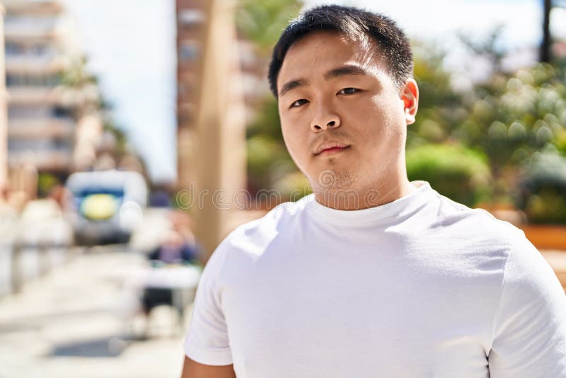 Young Chinese Man Standing with Relaxed Expression at Street Stock ...