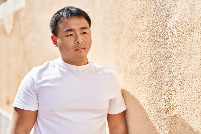Young Chinese Man Standing with Relaxed Expression at Street Stock ... Young Chinese Man Standing with Relaxed Expression at Street Stock ...