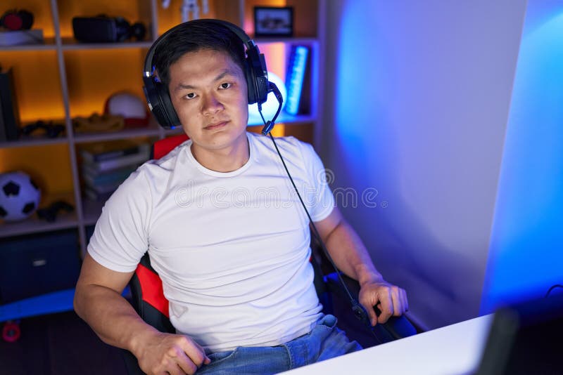 Young Chinese Man Streamer Sitting on Table with Serious Expression at ...