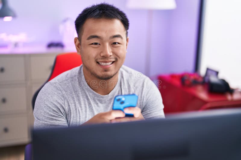 Young Chinese Man Streamer Using Computer and Smartphone at Gaming Room ...