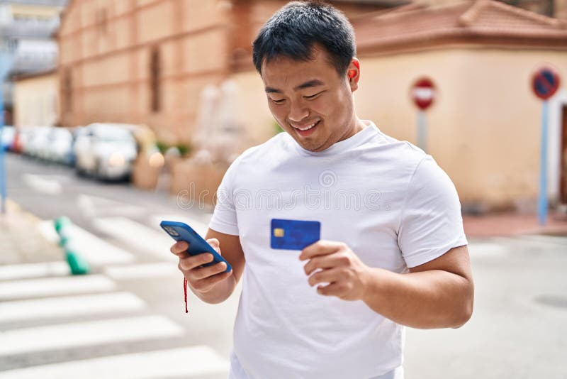 Young Chinese Man Using Smartphone and Credit Card at Street Stock ...