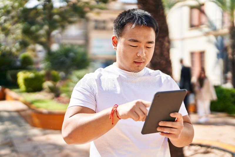 Young Chinese Man Student Sitting on Table with Relaxed Expression at ...