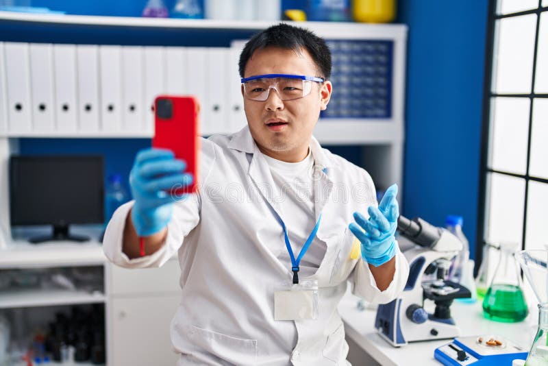Young Chinese Man Wearing Scientist Uniform Having Video Call at ...