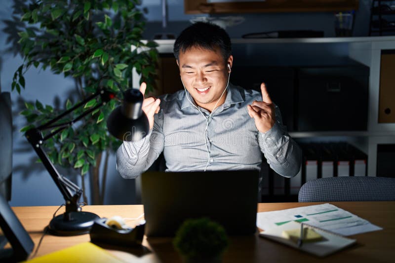Young Chinese Man Working Using Computer Laptop at Night Shouting with ...