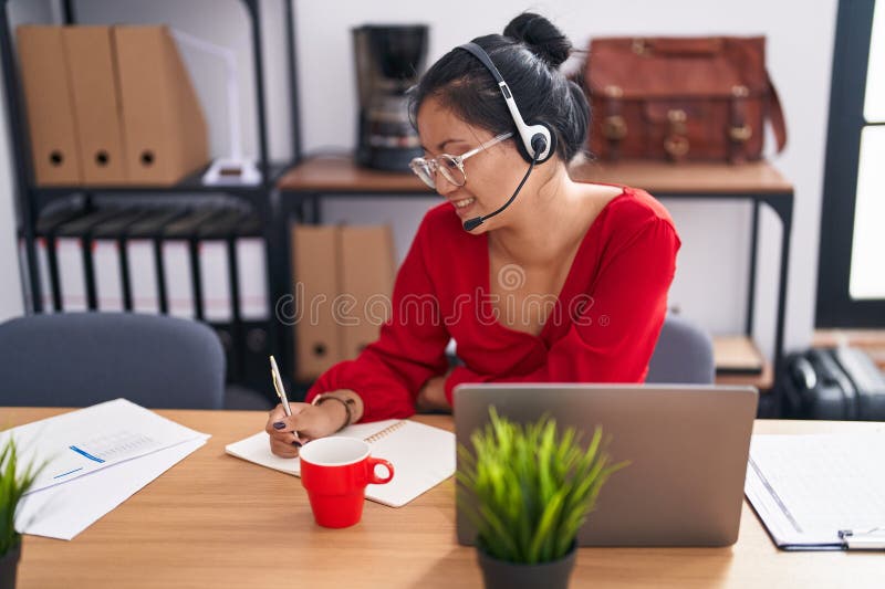 Young Chinese Woman Call Center Agent Writing on Notebook Working at ...