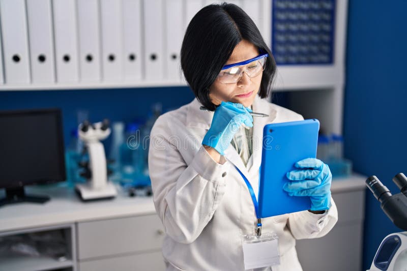 Young Chinese Woman Scientist Using Touchpad Working at Laboratory ...
