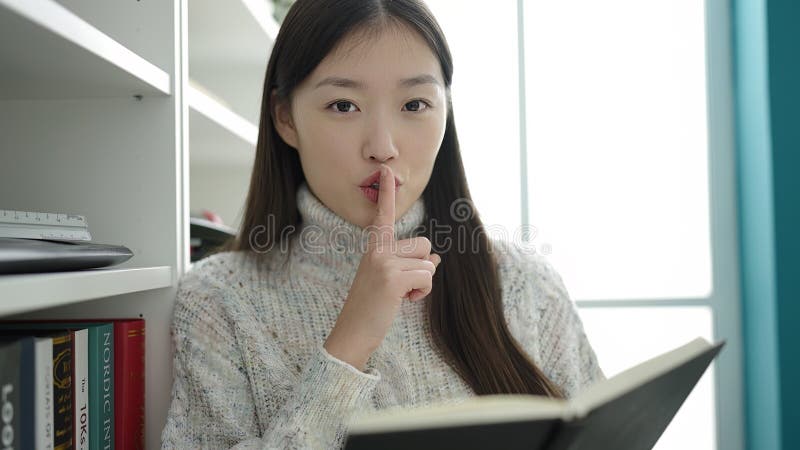Young Chinese Woman Student Reading Book Doing Silence Gesture at ...
