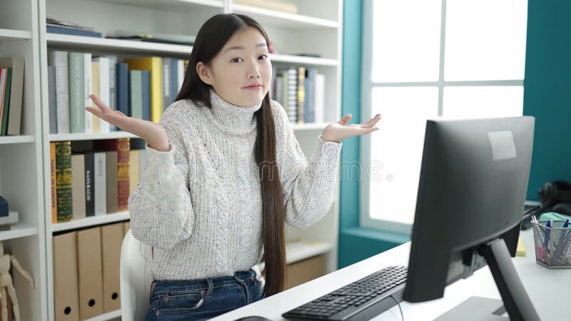 Young Chinese Woman Student Using Computer Doing I Dont Know Gesture at ...