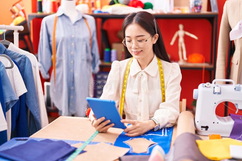 Young Chinese Woman Tailor Smiling Confident Using Touchpad at Atelier ...
