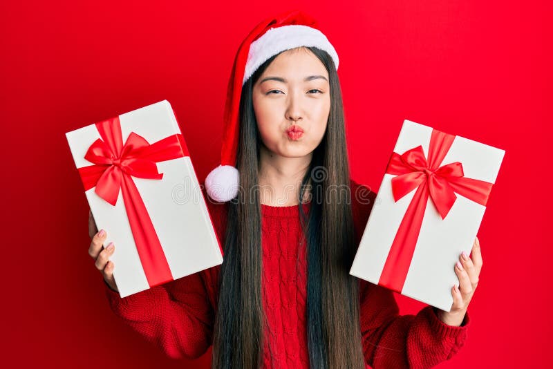 Young Chinese Woman Wearing Christmas Hat And Holding Ts Puffing