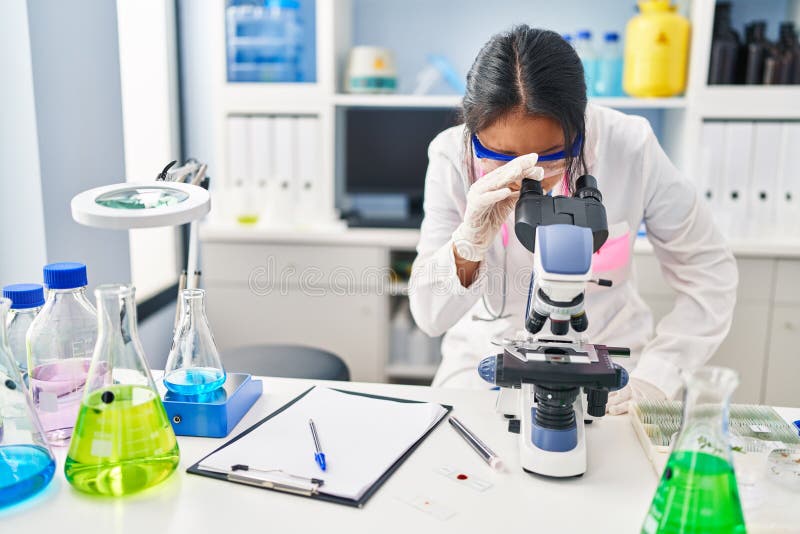Young Chinese Woman Wearing Scientist Uniform Using Microscope at ...