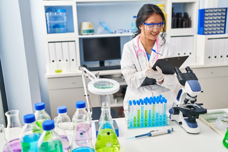 Young Chinese Woman Wearing Scientist Uniform Writing on Document at ... Young Chinese Woman Wearing Scientist Uniform Writing on Document at ...