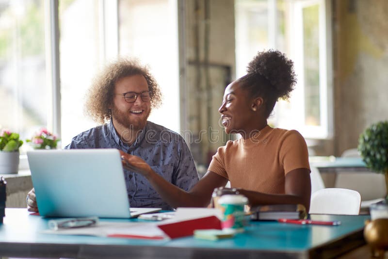 Young Colleagues Chatting while Working at Office Together Stock Image ...