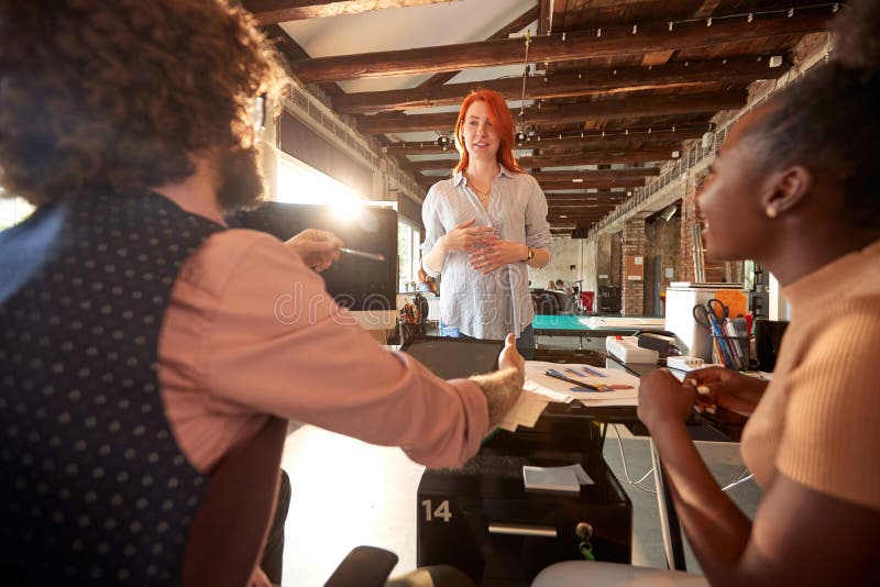 Young Colleagues at Workplace Talking about Project Working Together on ...