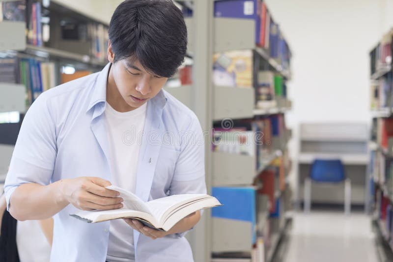 Young College Student Reading a Book in Library. Education and S Stock ...