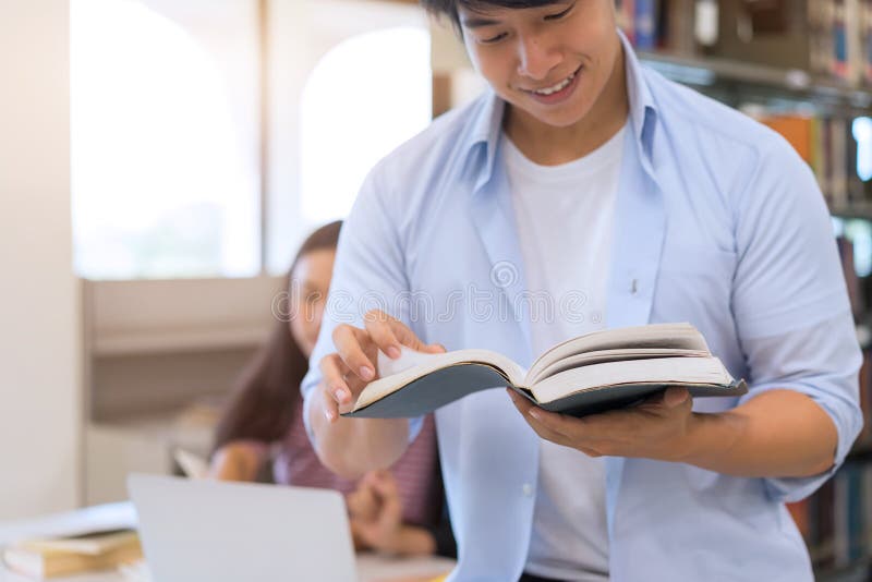 Young College Student Reading a Book in Library. Education and S Stock ...