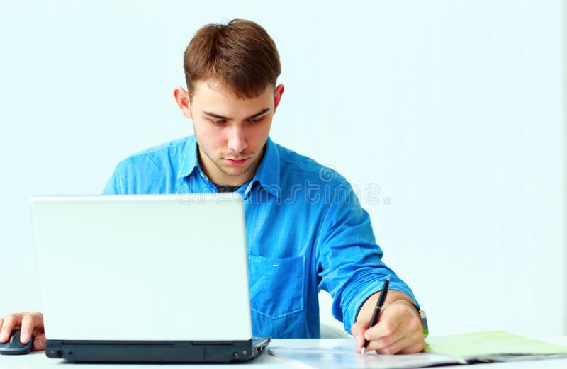 Young Concentrated Businessman Writing Notes Down with Laptop Stock ...