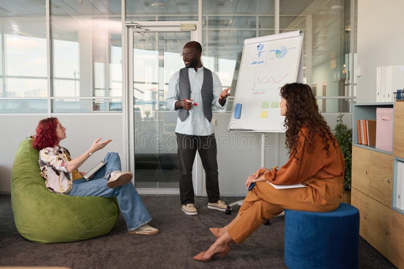 Young Confident Businessmen and His Colleagues Discussing Graphic Data ...