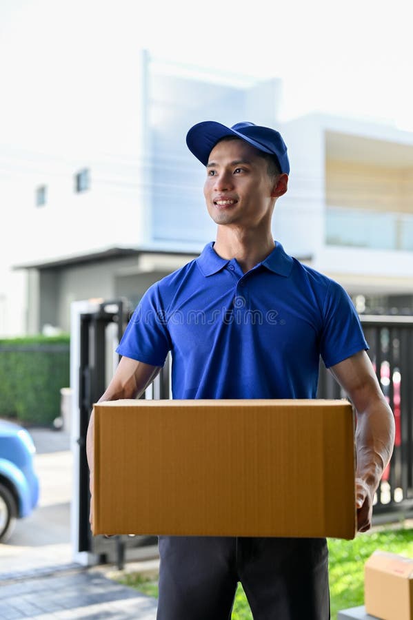Young Confident Delivery Man Wearing Blue Uniform Holding Parcel For