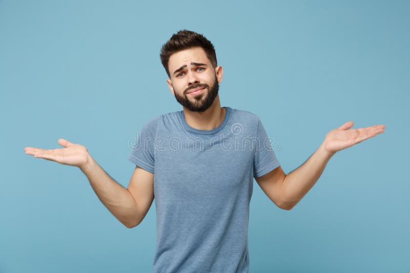 Young Confused Man In Casual Clothes Posing Isolated On Blue Wall