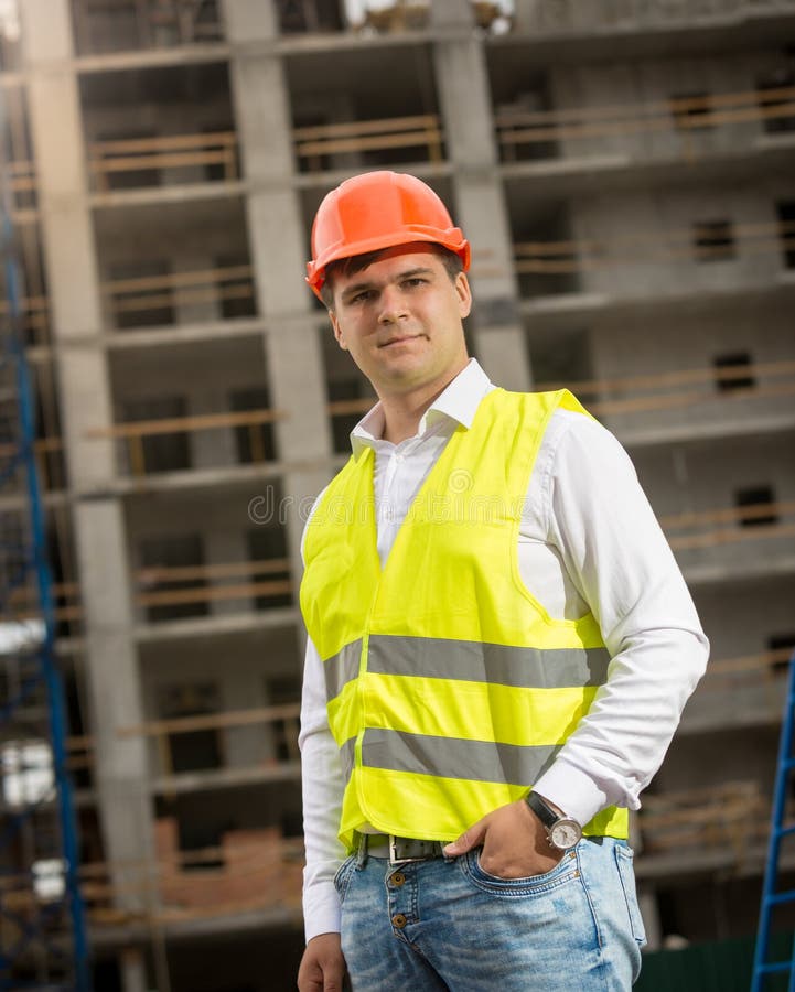 Young Construction Engineer Standing at Building Site and Looking at ...