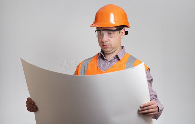 Young Construction Worker in Hard Hat with Opened Paper Project in ...
