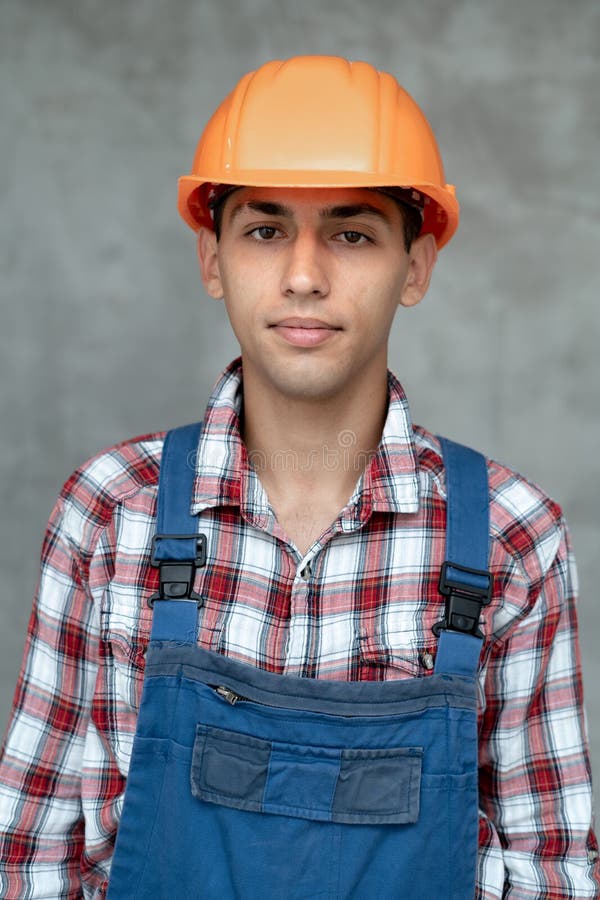 Young Construction Worker in Hard Hat and Overalls on Gray Background ...