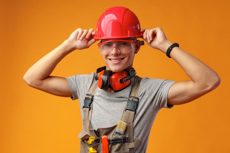 Young Construction Worker in Helmet and Uniform Posing on Yellow ...