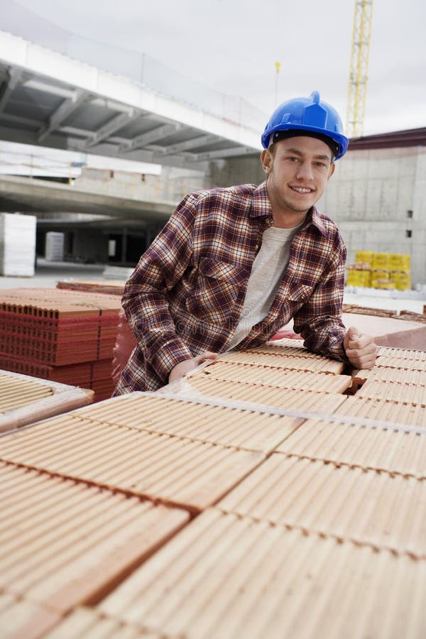Young Construction Worker Leaning on Tiles Stock Image - Image of ...