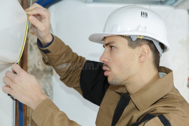 Young Construction Worker Measuring Wall Stock Photo - Image of worker ...