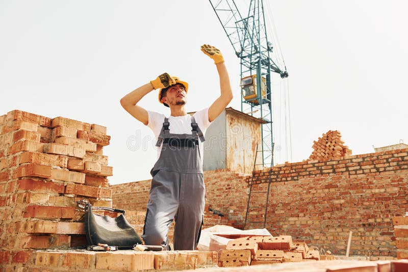 Young Construction Worker in Uniform is Busy at the Unfinished Building ...