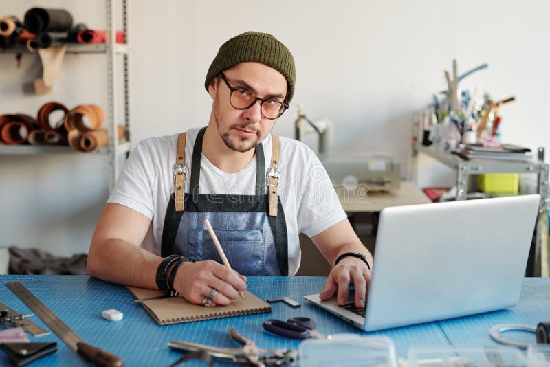 Young Contemporary Leatherworker in Workwear Making Sketch of New Items ...